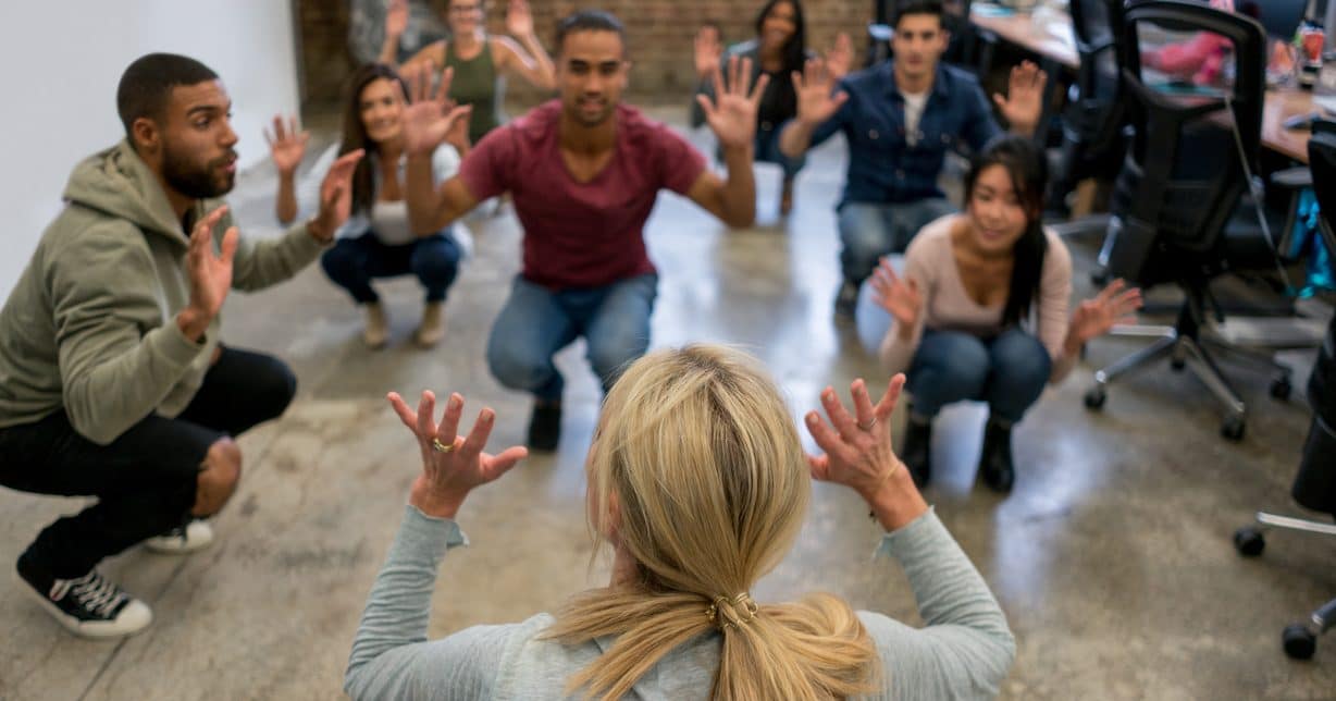 Group of people taking a active break at the office - Ritualize